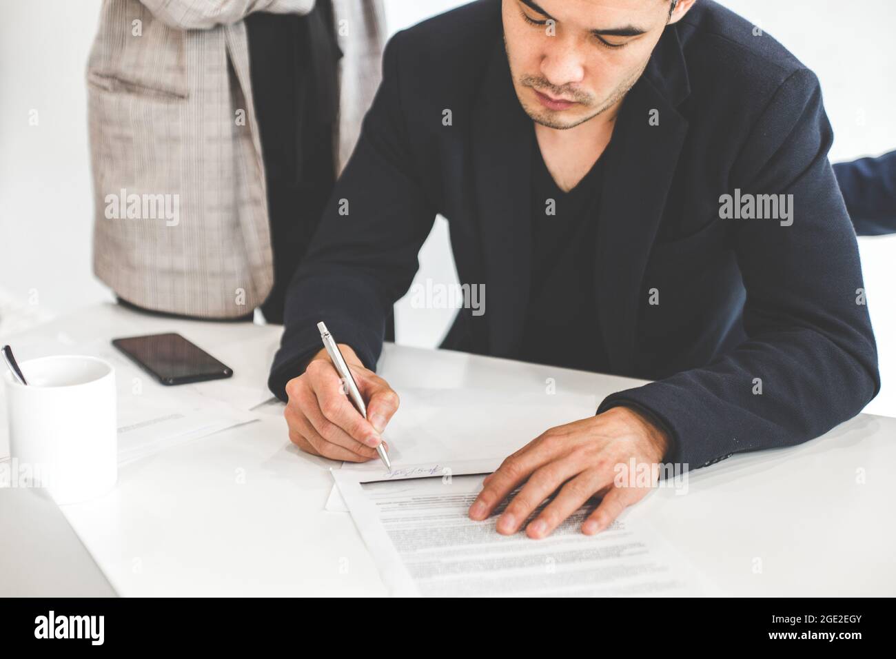 Asian man signing contract, hand putting signature on official document ...