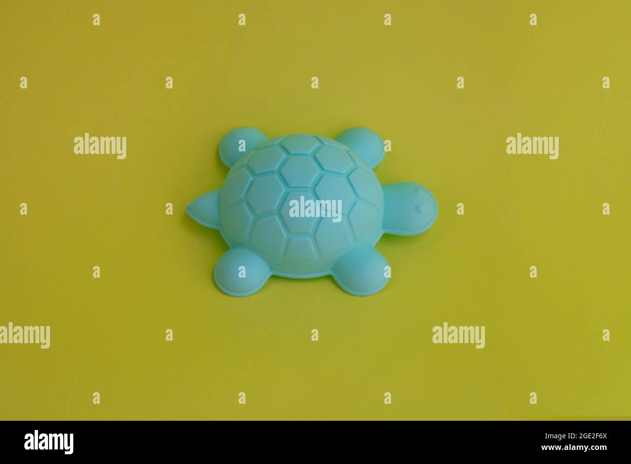 A blue plastic turtle toy, isolated on a yellow background Stock Photo ...