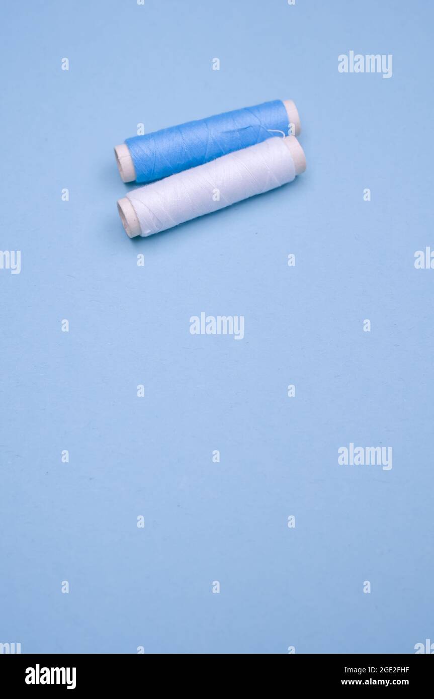 Vertical closeup of threads on the aesthetic blue background Stock ...