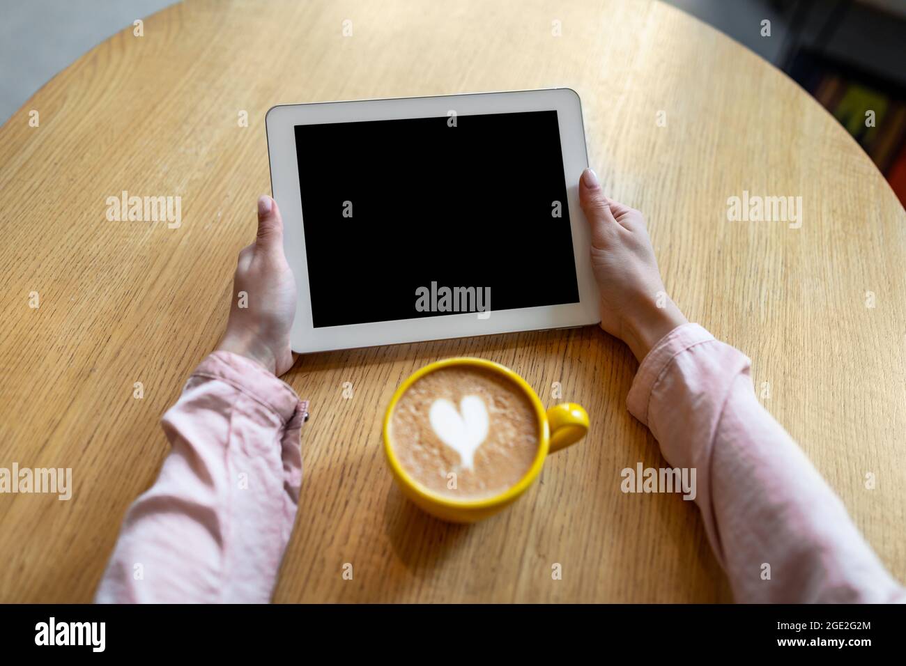 Breakfast at cafe. Unrecognizable lady holding tablet with empty blank ...