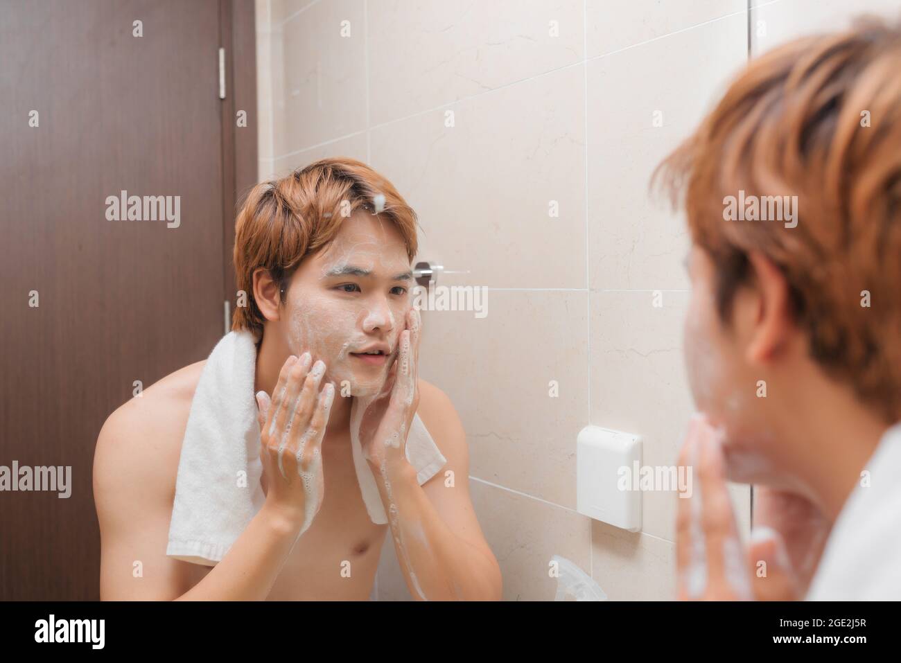 Handsome man washing face in bathroom Stock Photo - Alamy