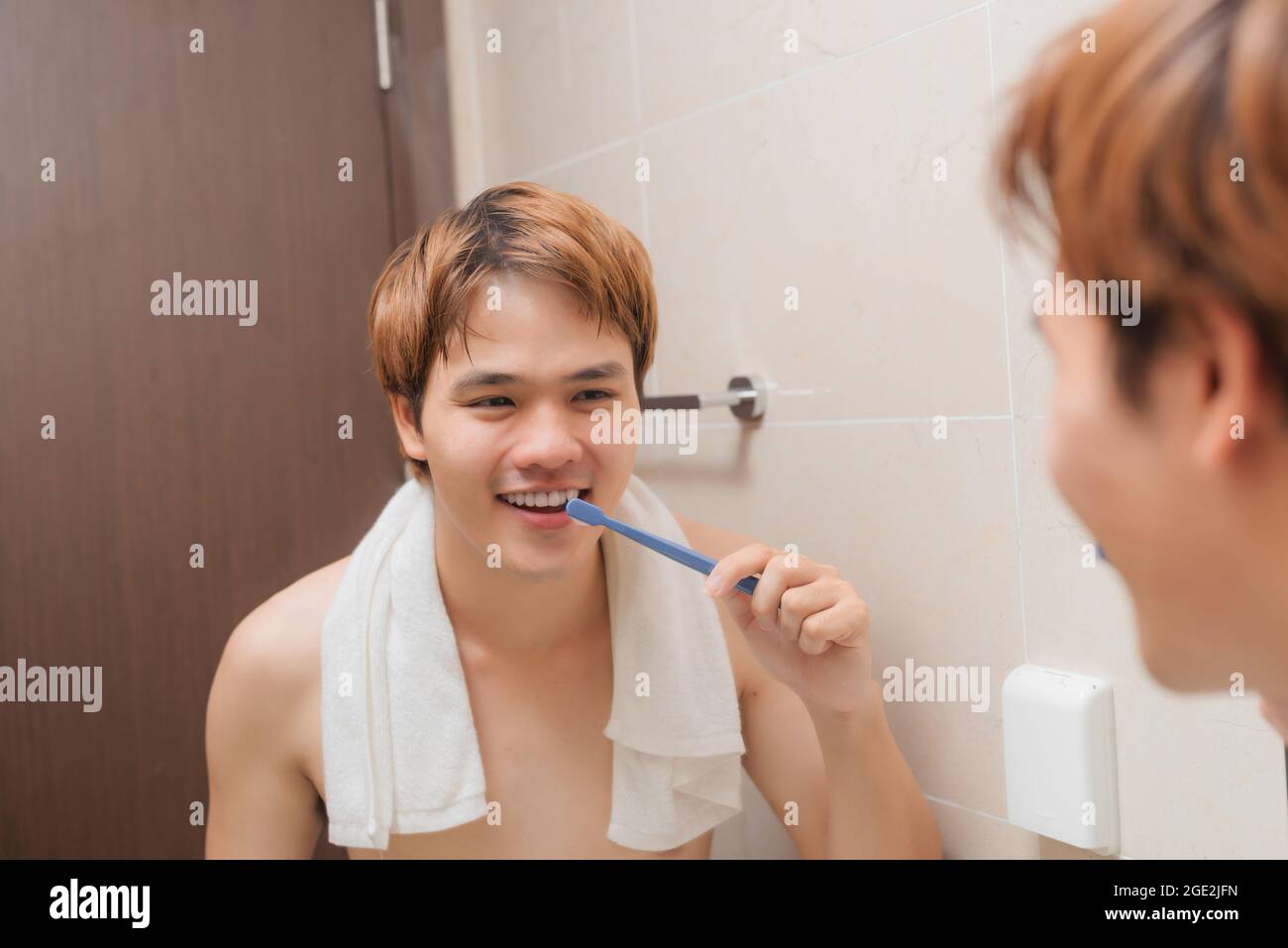 Handsome man brushing his teeth in morning in bathroom Stock Photo - Alamy