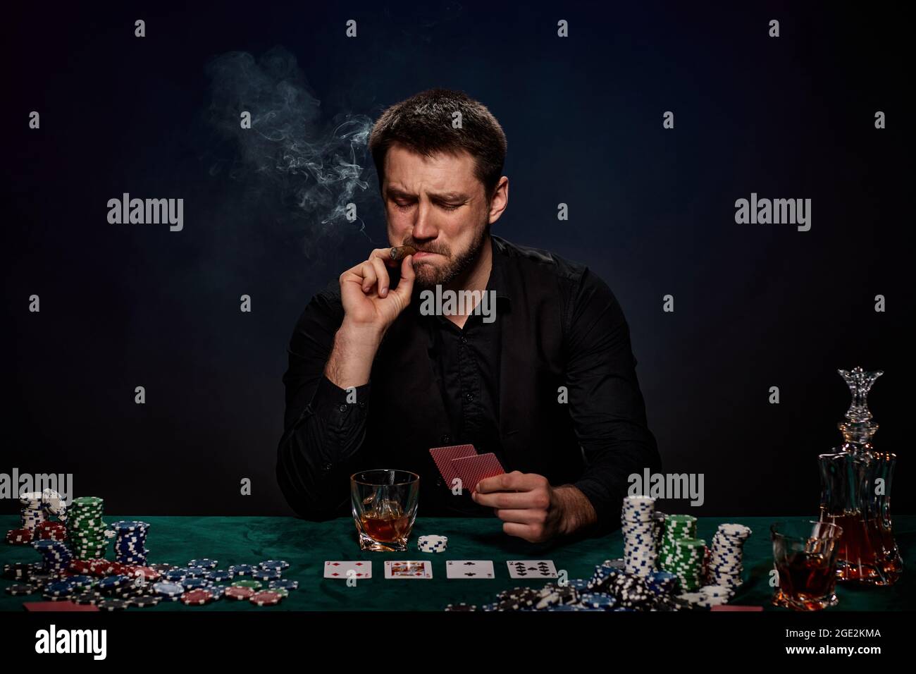Man playing poker looking cards hi-res stock photography and images - Alamy