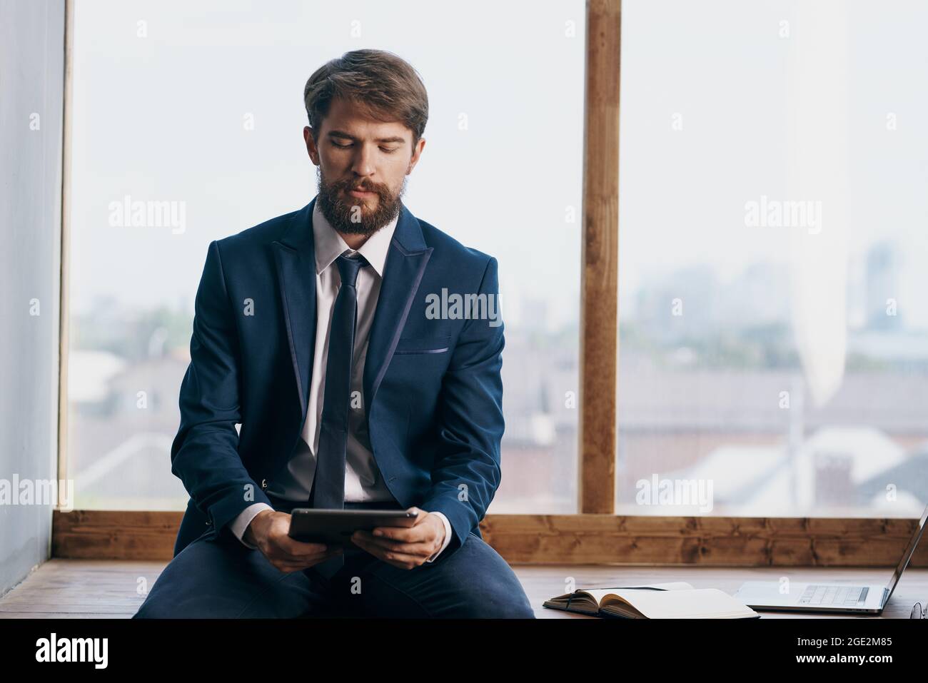 The man in a suit near the window with a laptop technology Stock Photo ...