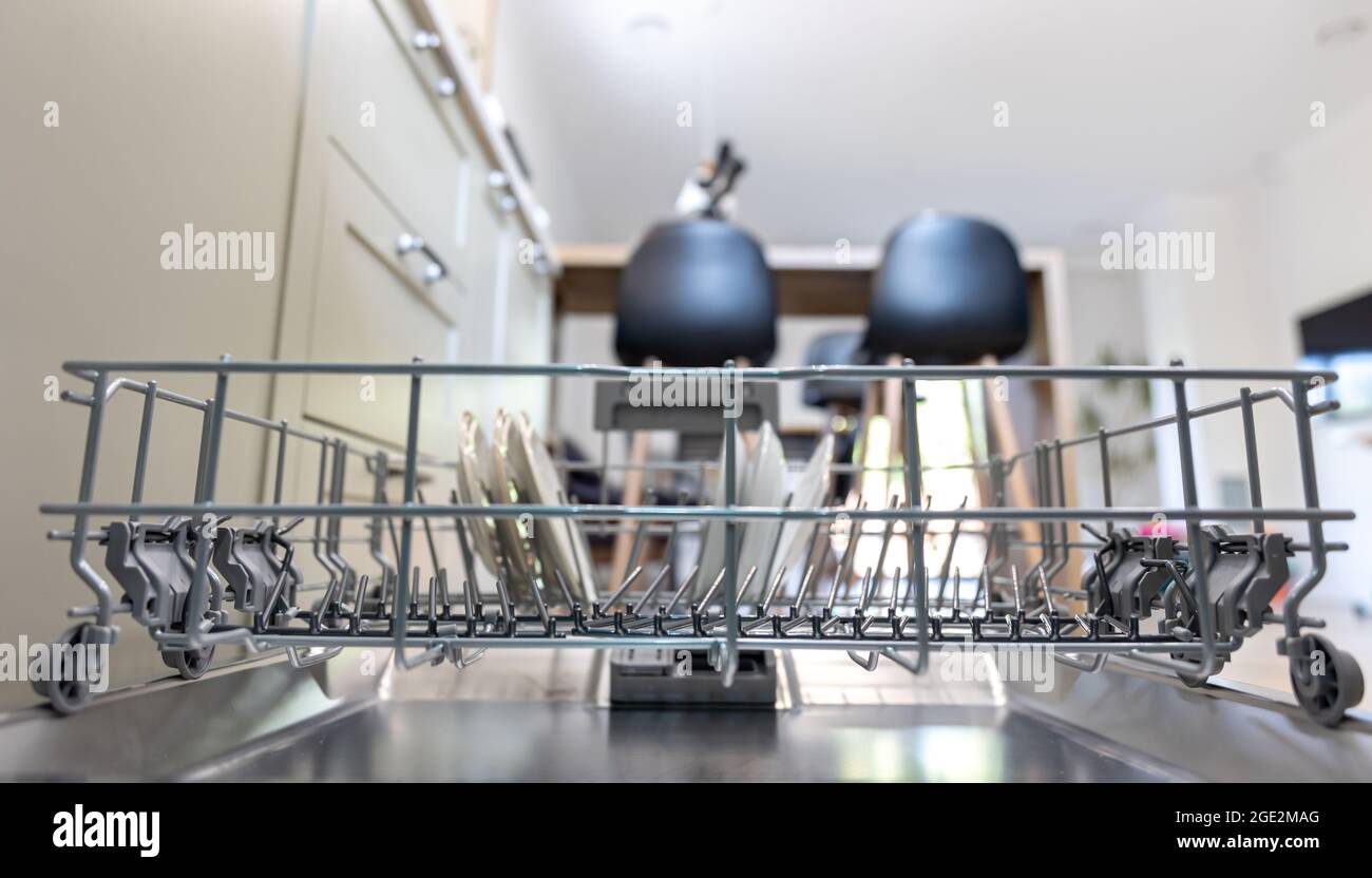 Open dishwasher with clean dishes on blurred kitchen background Stock ...