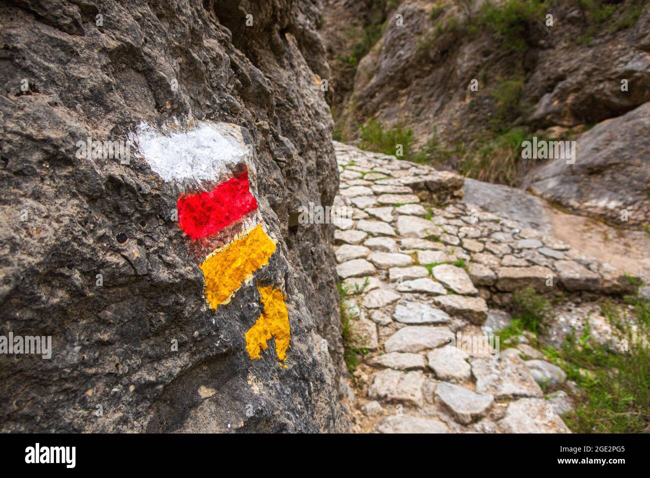 Closeup of colorful marks and a yellow arrow on the rock showing the ...