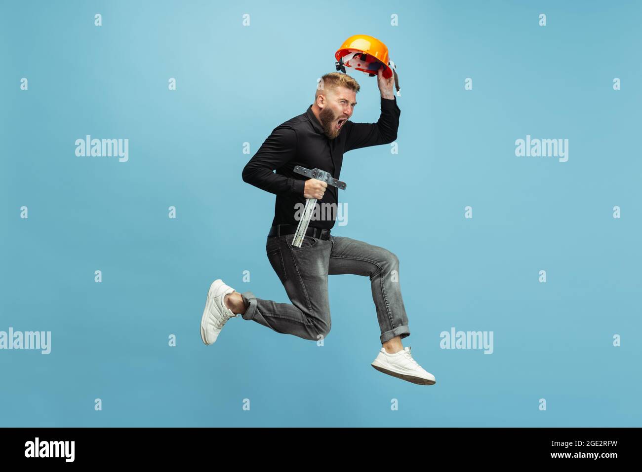 Funny portrait of young bearded man, builder, designer or architect ...