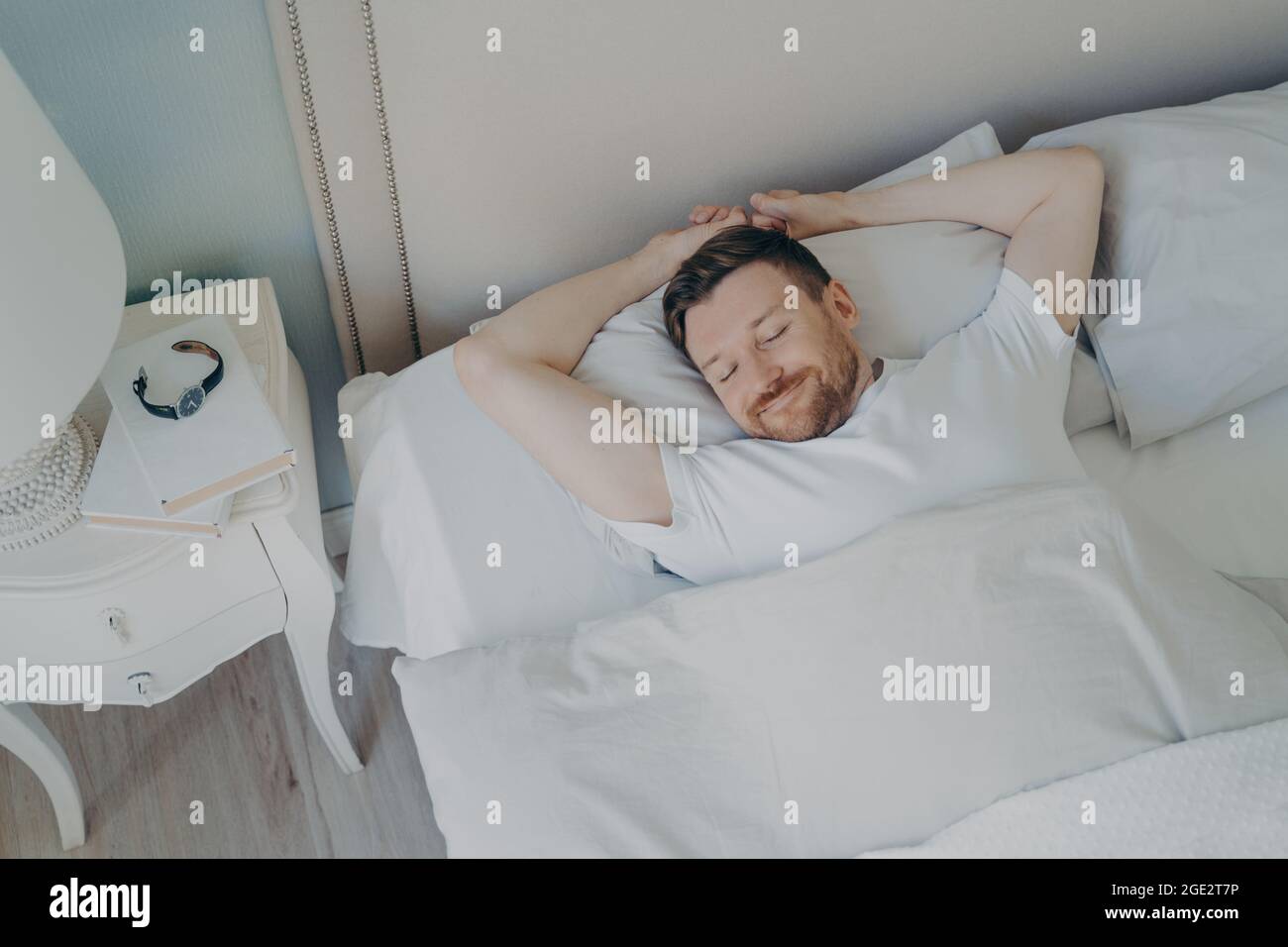 Young happy relaxed caucasian man sleeping in bed Stock Photo - Alamy