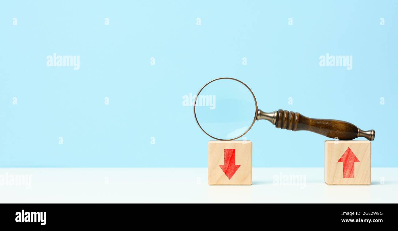 wooden magnifier on wooden cubes with up and down arrows. Market ...