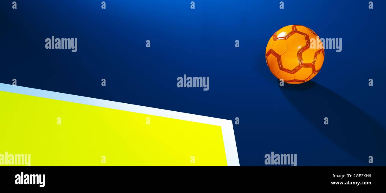 Orange futsal indoor soccer ball laying outside the field with shadow ...