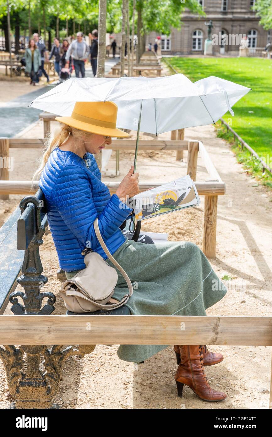Lady sitting on a park bench hi-res stock photography and images - Alamy