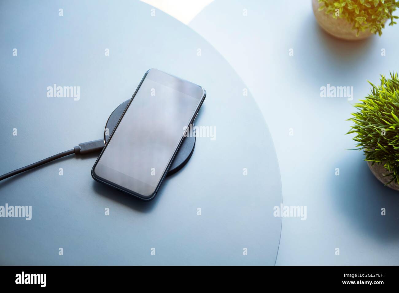 Top down view of using wireless charges for recharging smartphone ...