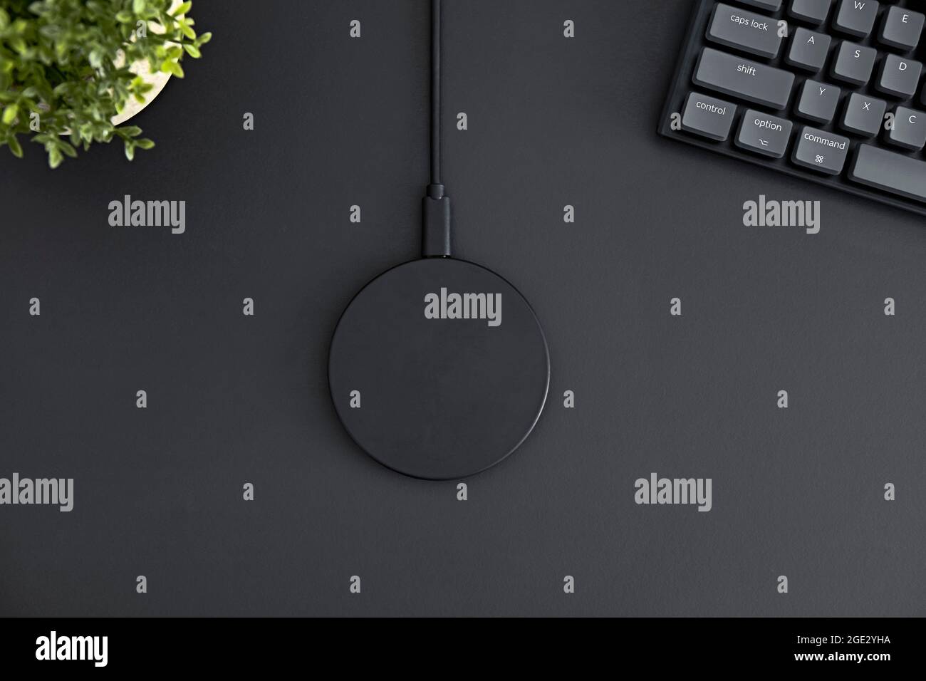 Top down view of office workplace. Black round plastic wireless charger ...