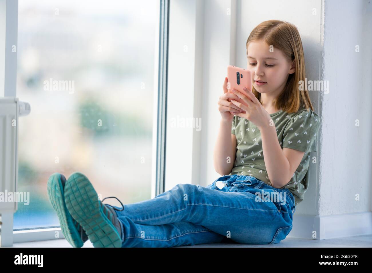 Preteen girl with smartphone Stock Photo - Alamy