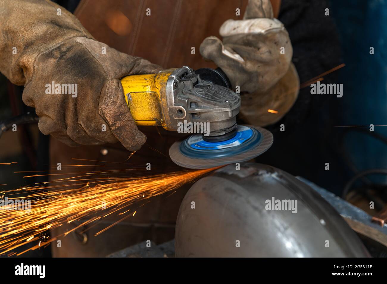 man sanding metal to make a metal object Stock Photo - Alamy
