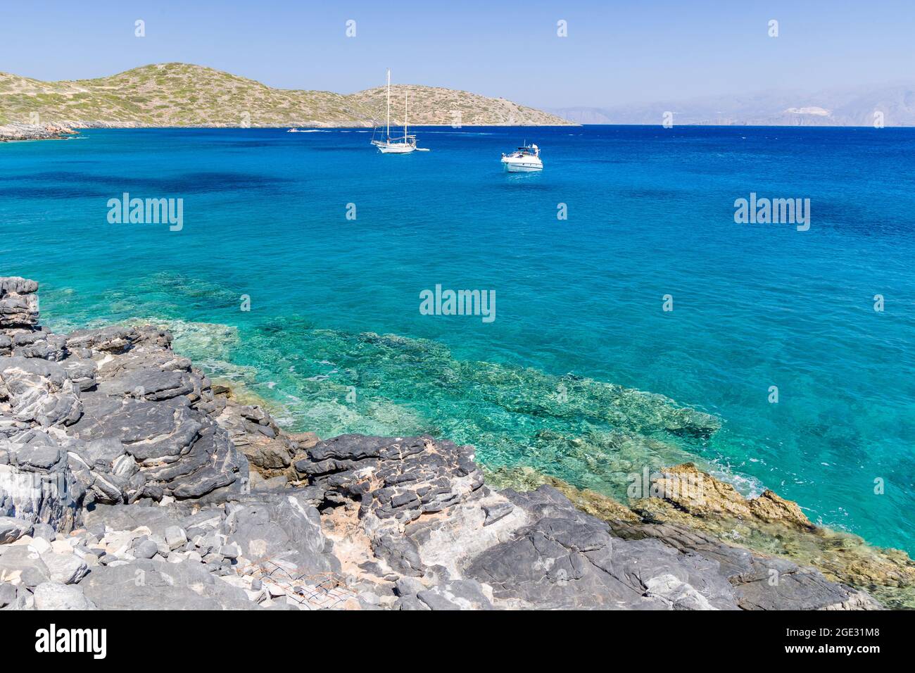 Rocky coastline and clear, blue ocean in Elounda, Crete, Greece Stock ...
