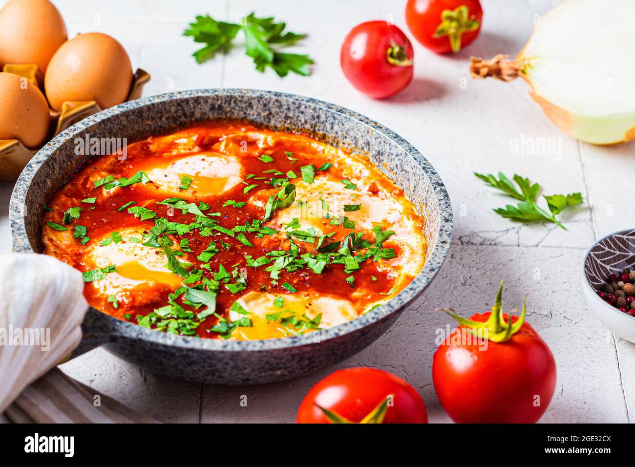 Traditional Israeli shakshuka in a gray frying pan. Fried eggs in ...
