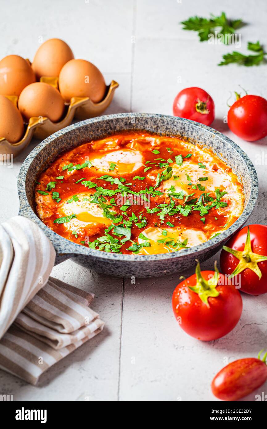 Traditional Israeli shakshuka in a gray frying pan. Fried eggs in ...