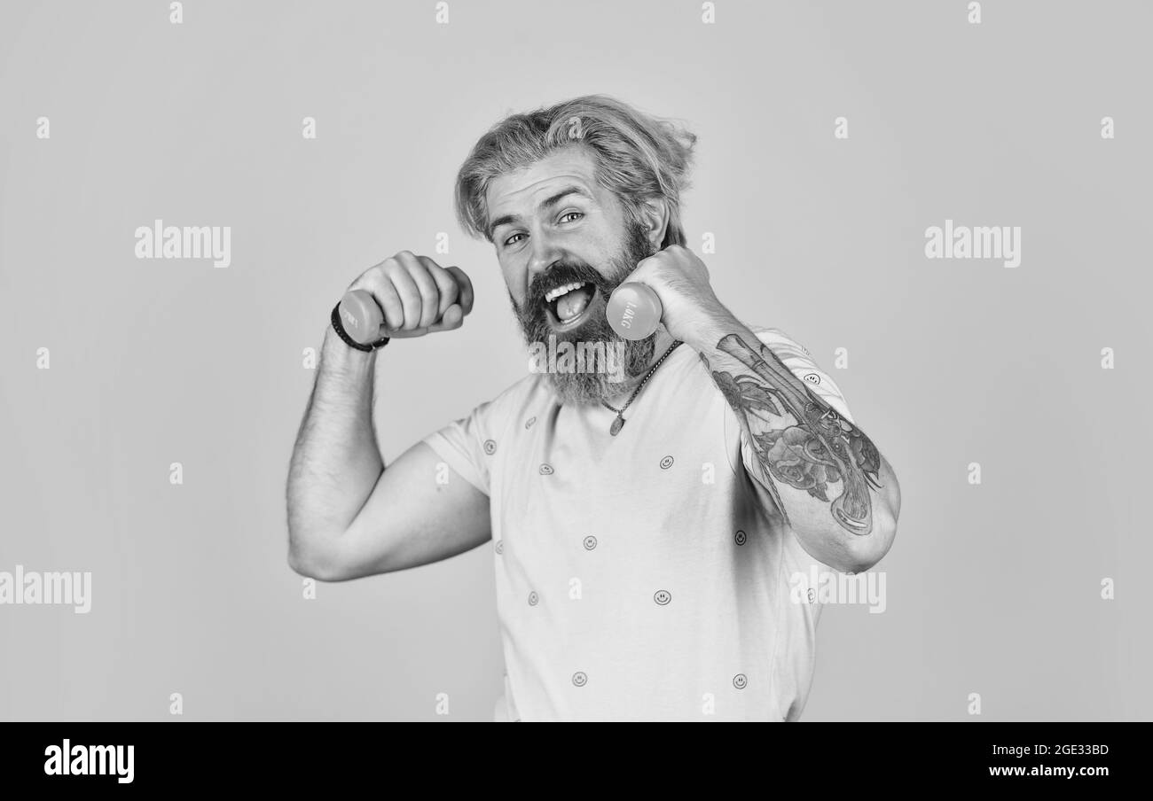 Inappropriate load. Physical rehabilitation. Happy man hold dumbbells ...