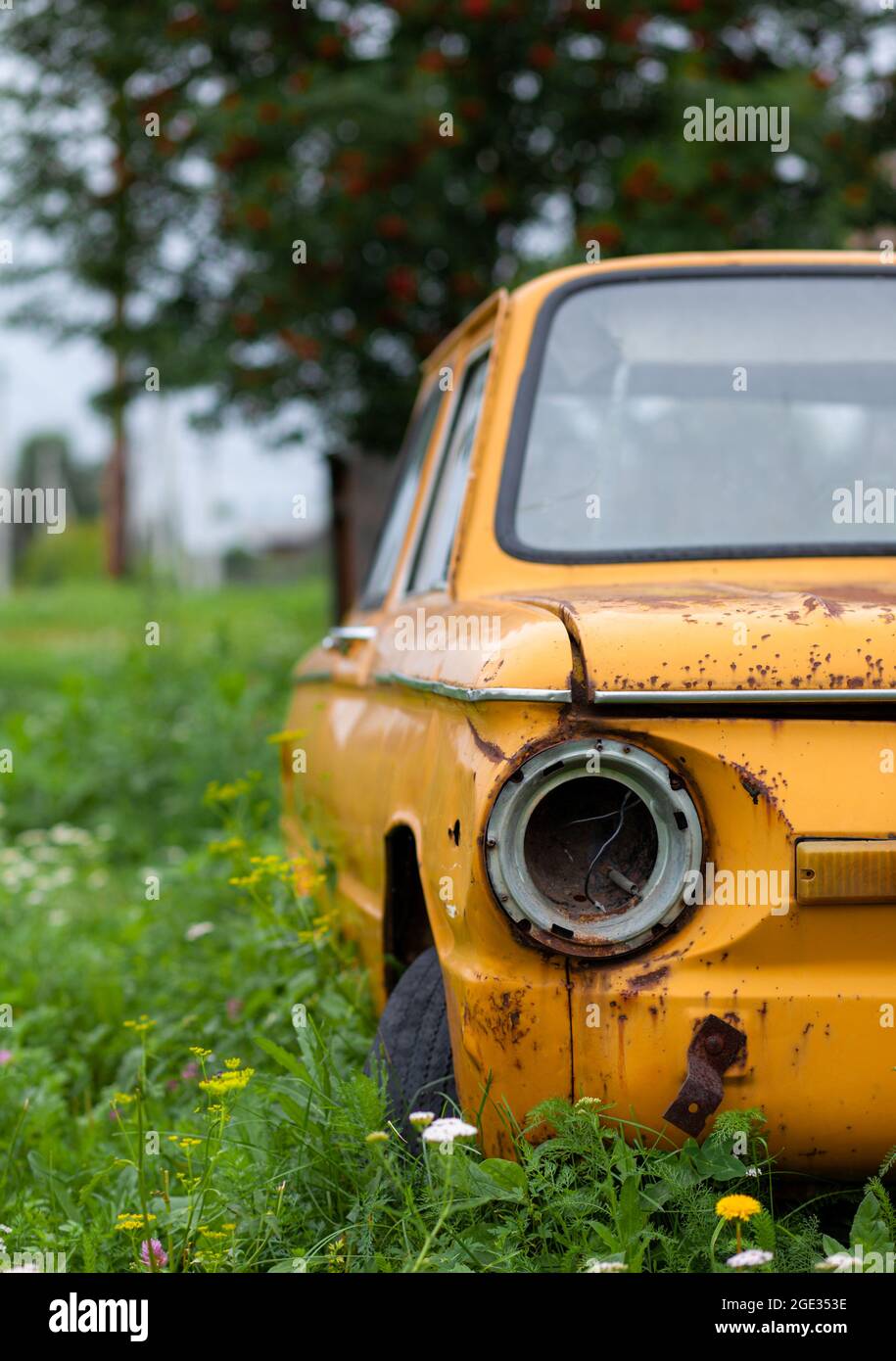Old yellow wrecked car in vintage style. Abandoned rusty yellow car ...
