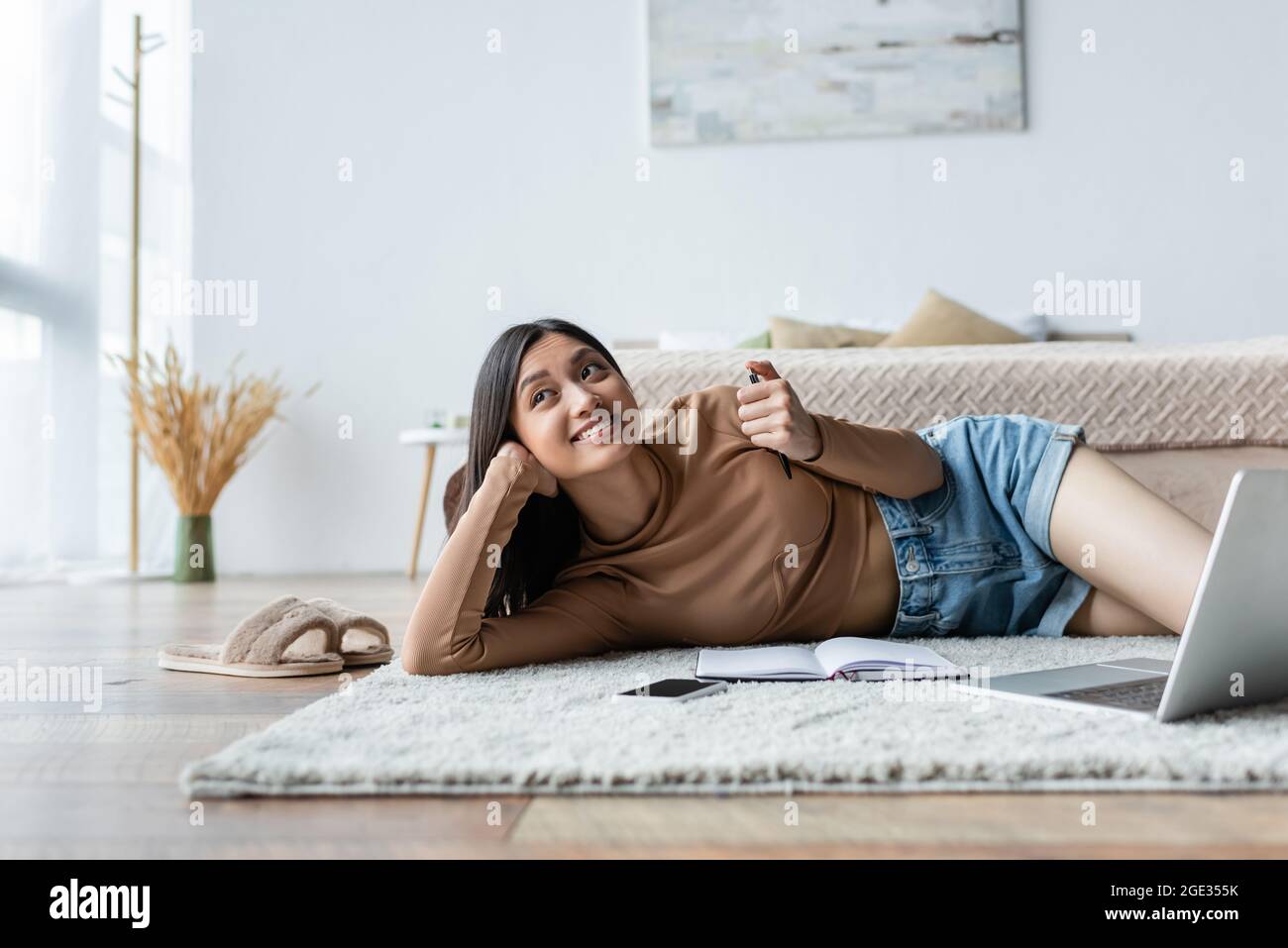 Young woman lying on carpet at home hi-res stock photography and images ...
