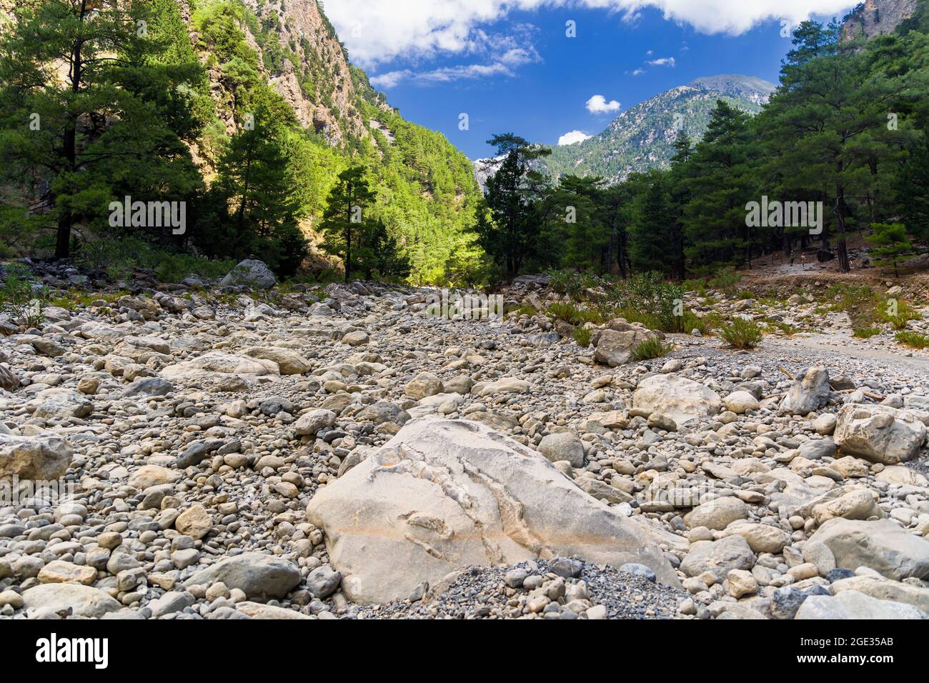 Dry riverbed and towering cliffs in a huge natural gorge (Samaria Gorge ...