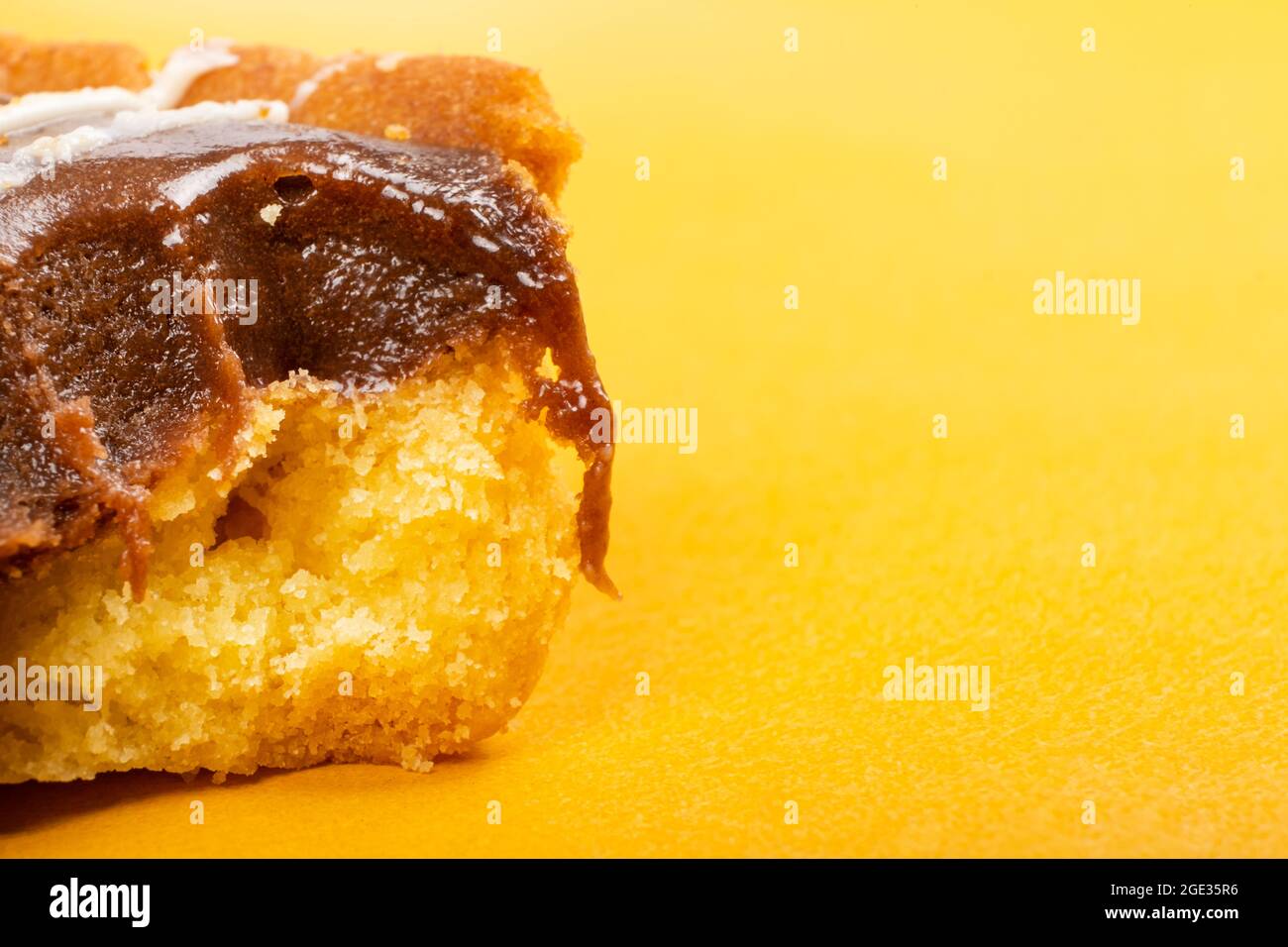 bitten off cake on yellow background with copy space Stock Photo - Alamy