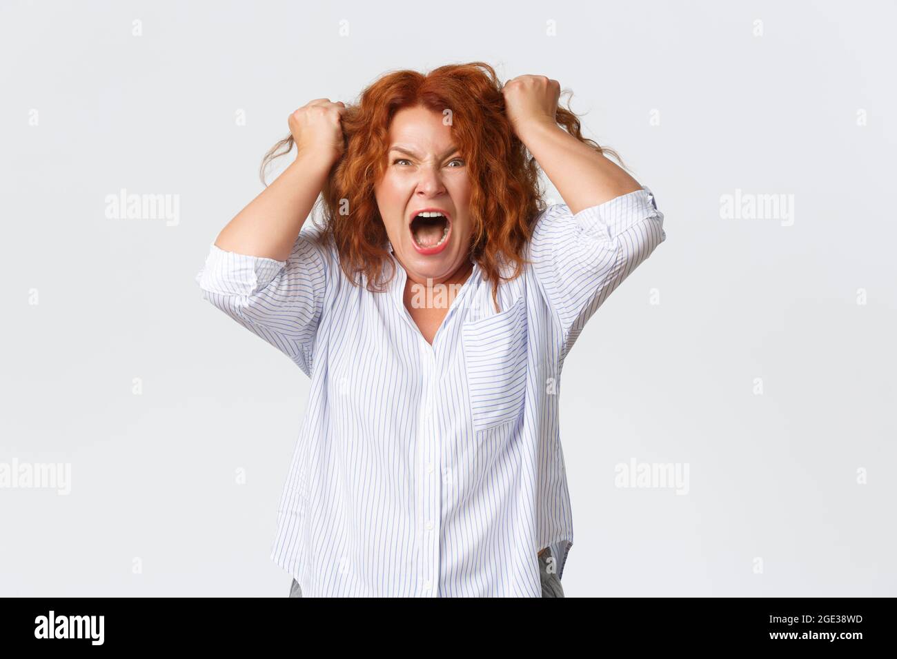 Angry and hateful middle-aged redhead woman looking outraged and ...