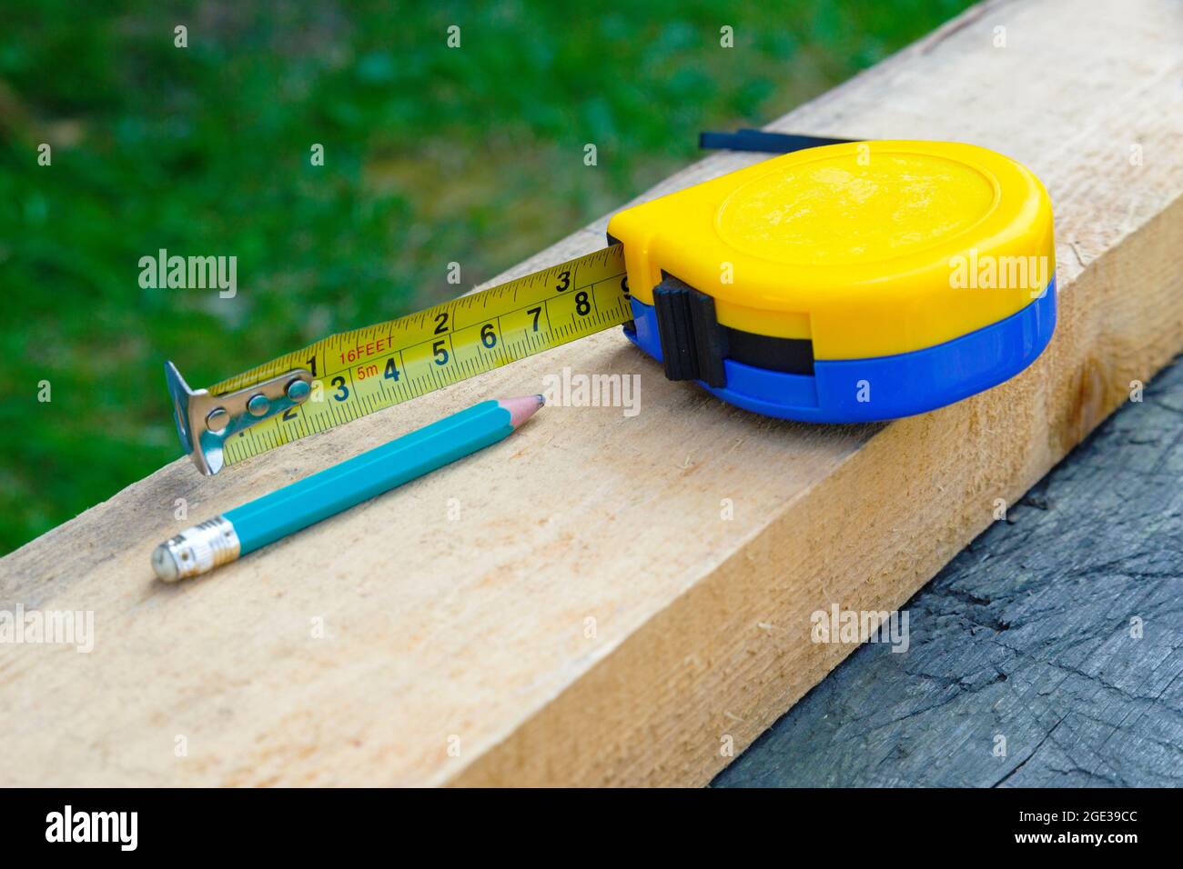 Construction measuring tape, pencil for marking on a wooden board. Wood ...