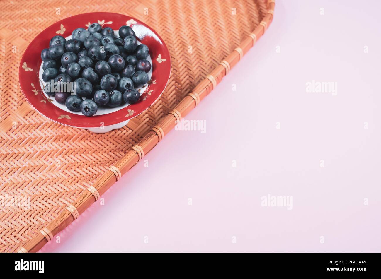 Closeup of a red plate with blueberry on the aesthetic pink background ...