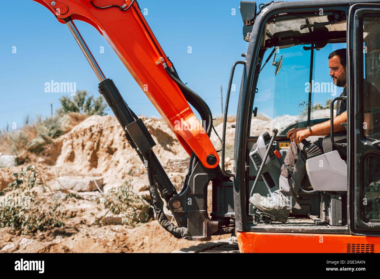 Man driving an excavator on a construction site Stock Photo - Alamy