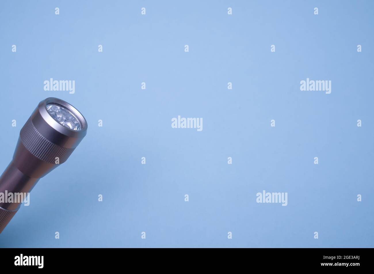 Closeup of a metallic flashlight on the aesthetic blue background Stock ...