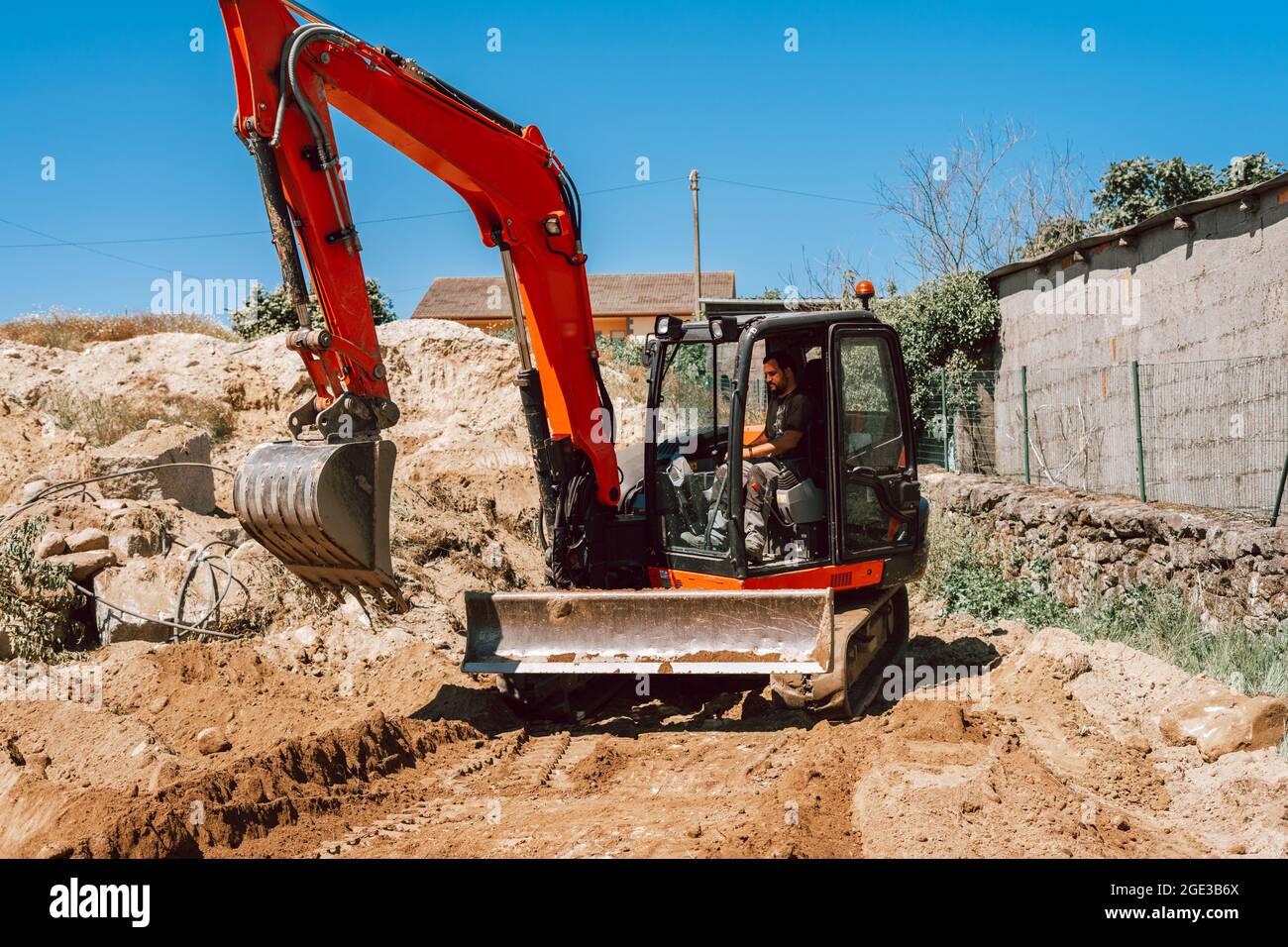 Worker driving an excavator on a construction site Stock Photo - Alamy