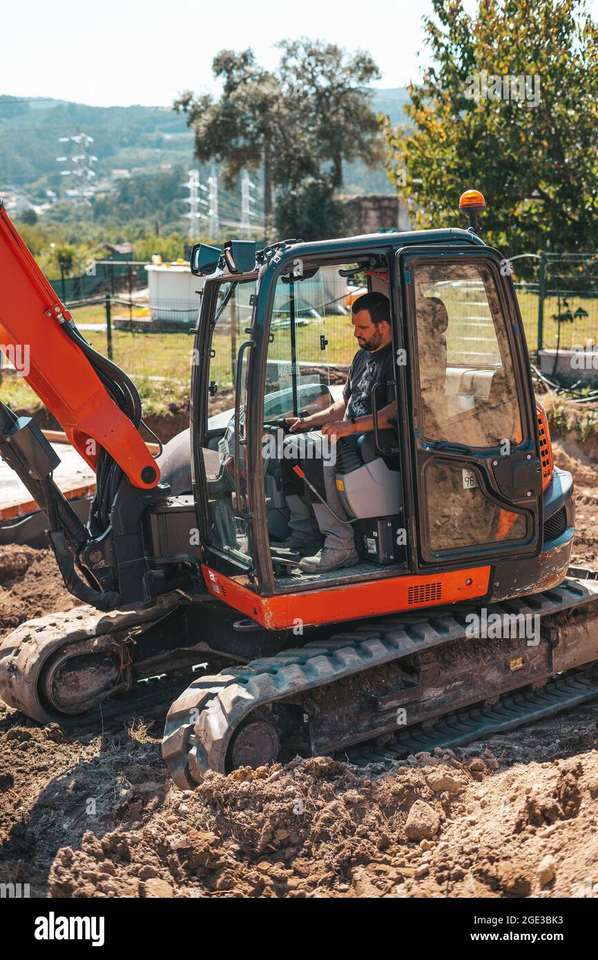 Worker driving an excavator on a construction site Stock Photo - Alamy