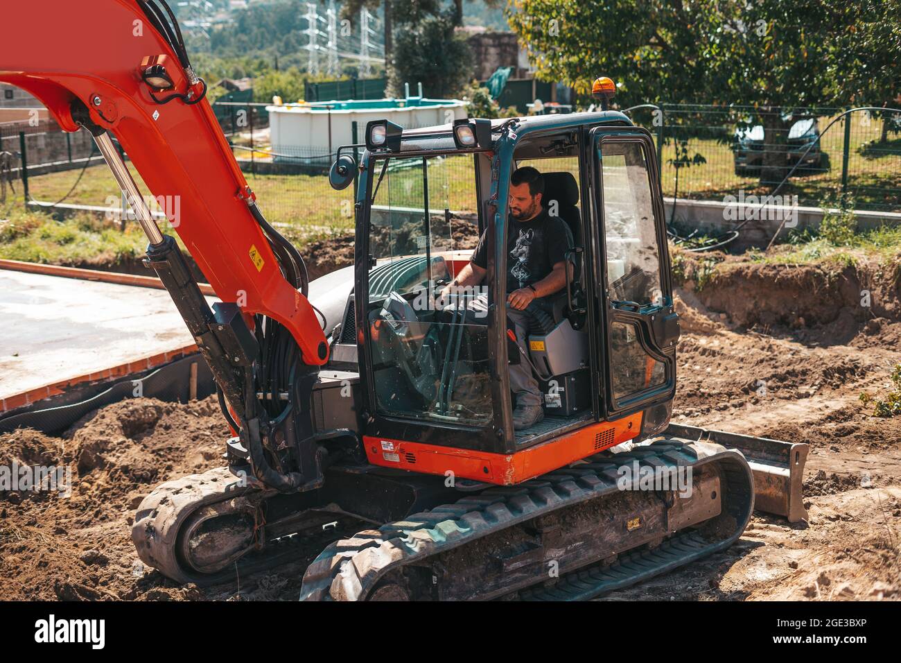 Worker driving an excavator on a construction site Stock Photo - Alamy