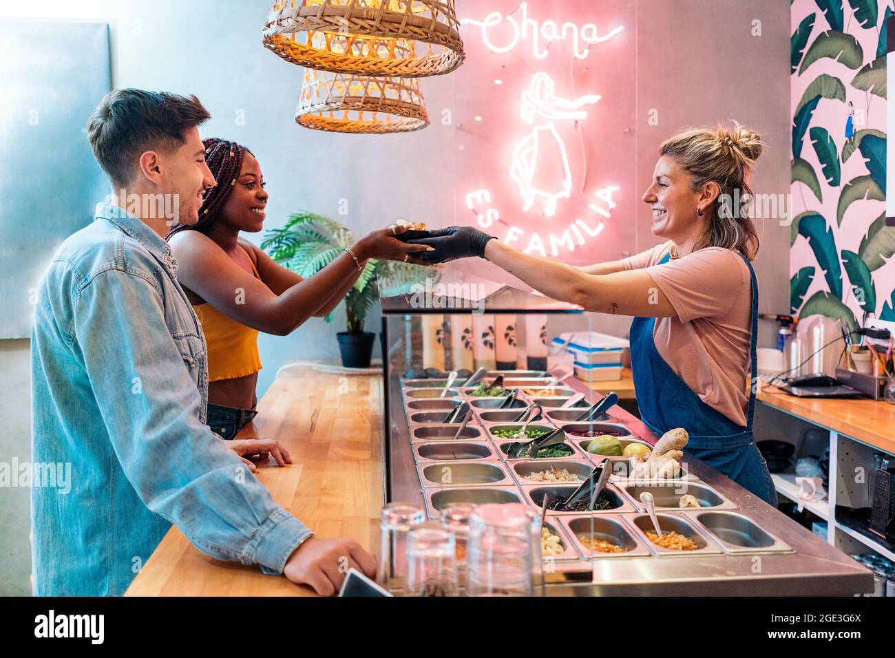 African american woman and her friend buying a poke bowl in a cool ...