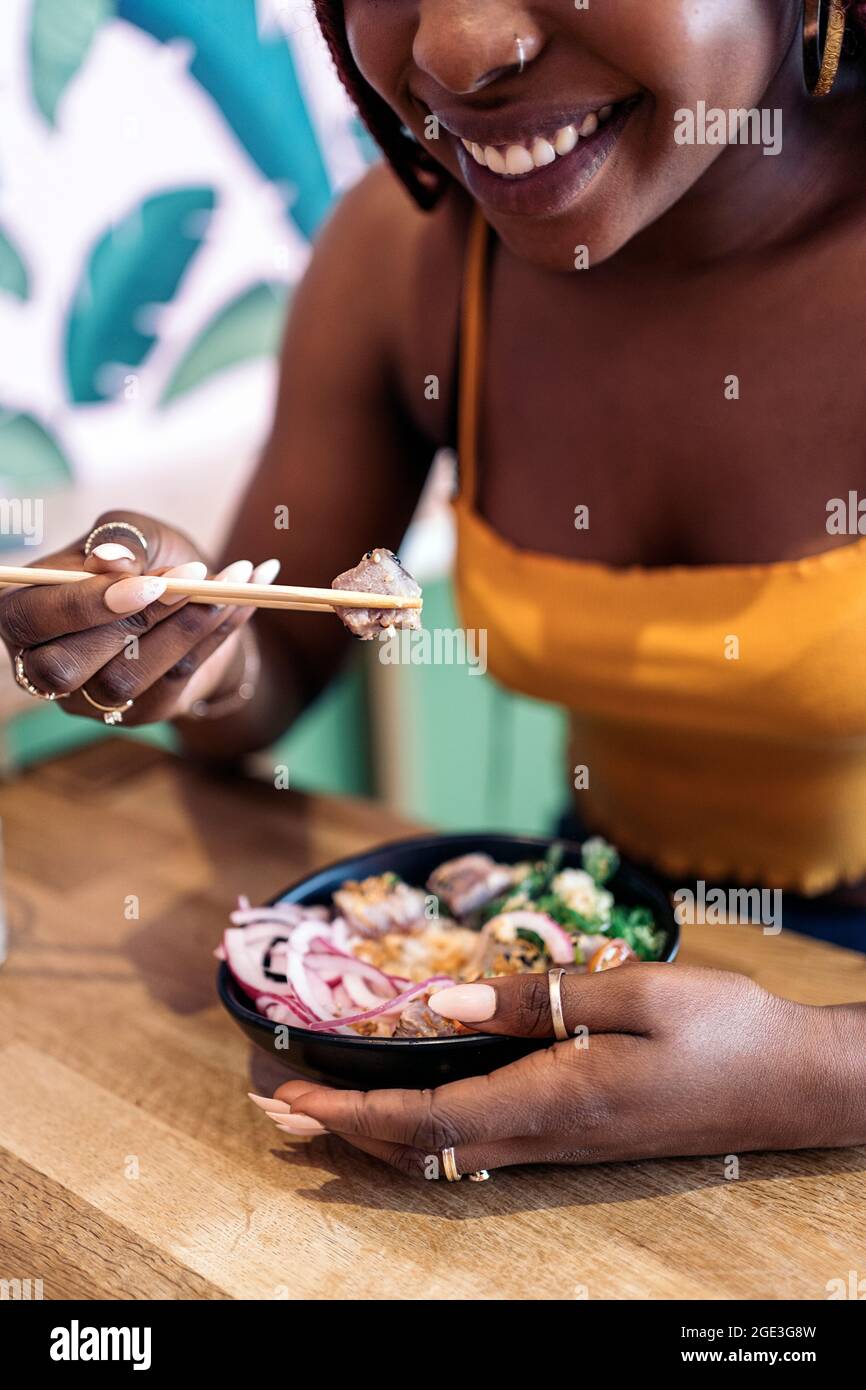 Unrecognized african woman sitting in a restaurant enjoying a healthy ...