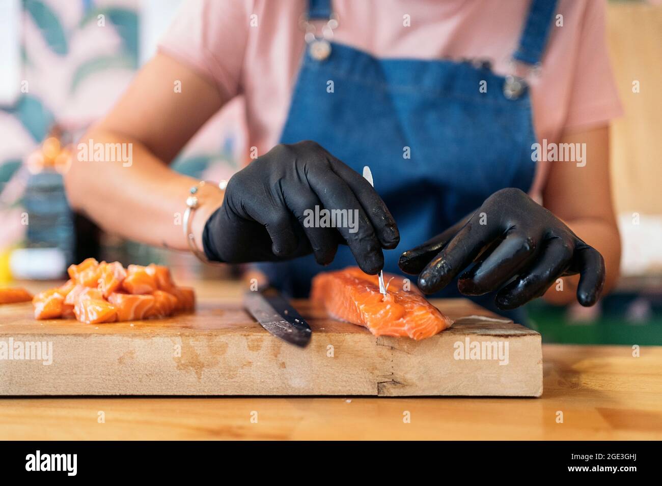 Unrecognized restaurant worker wearing latex gloves using a knife to ...
