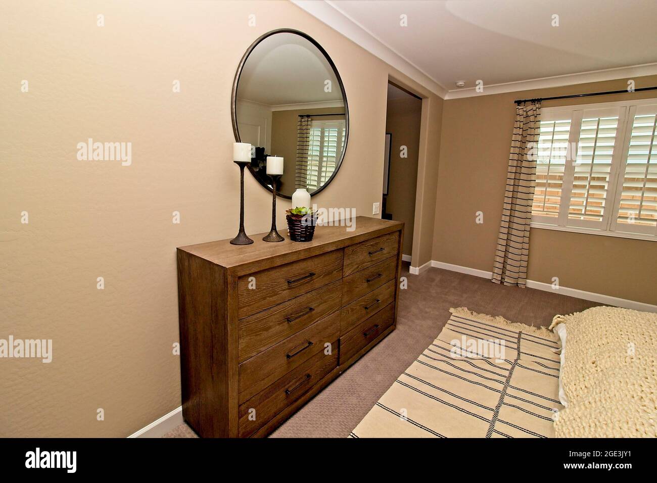 Wooden Chest And Circular Mirror In Bedroom Stock Photo - Alamy