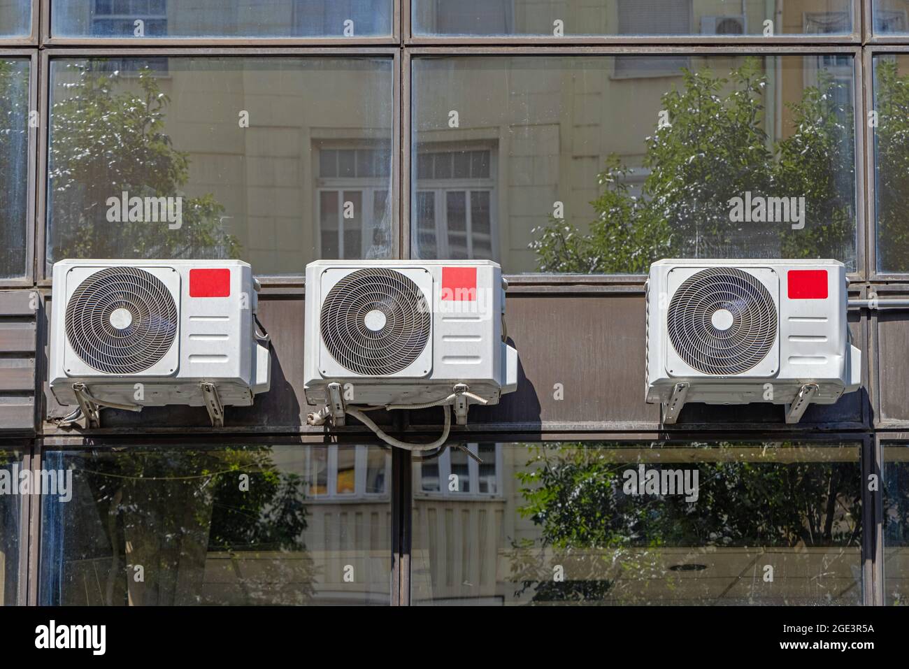 Three Air Conditioners Units at Glass Office Building Stock Photo - Alamy
