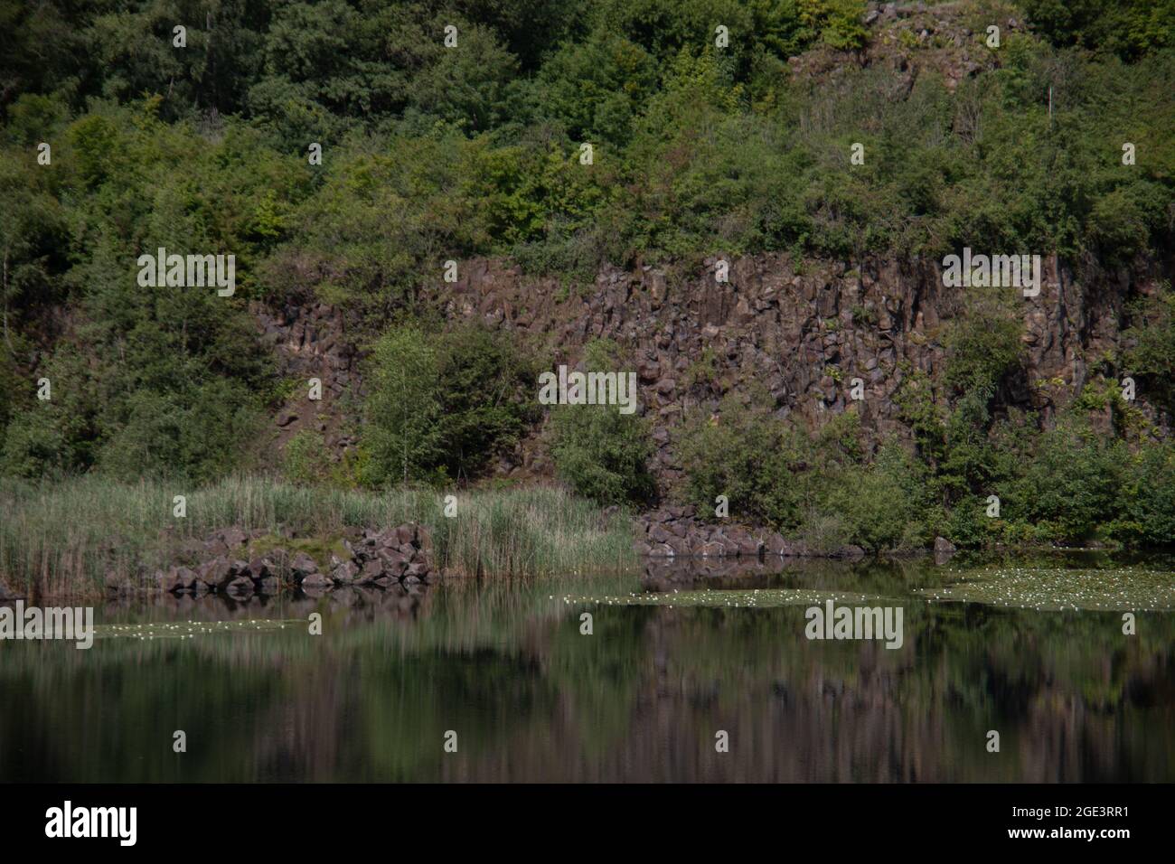 Mountain slope made of basalt rock on the lake Stock Photo - Alamy