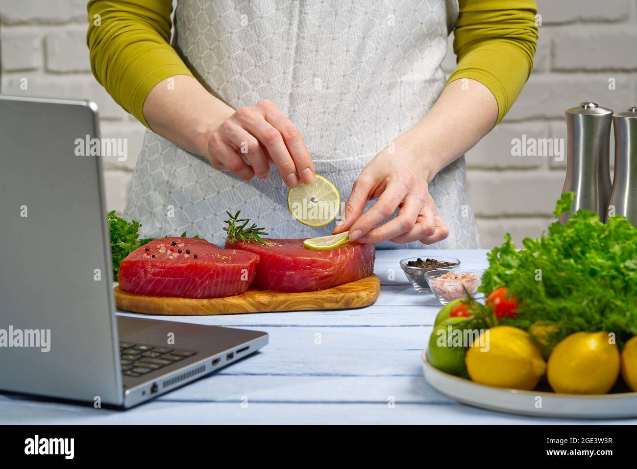 cooking and computer laptop concept. cooking woman in kitchen with pc ...
