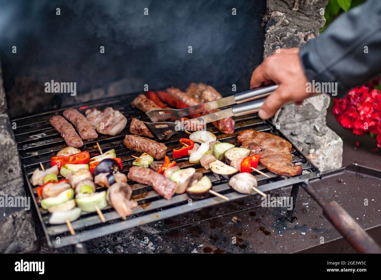 Barbecue. Man in the countryside burns dry branches to make charcoal ...