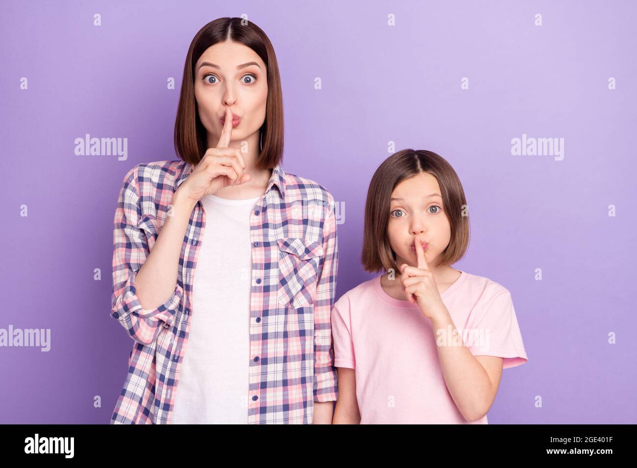 Portrait of two attractive mysterious girls best friends showing shh ...