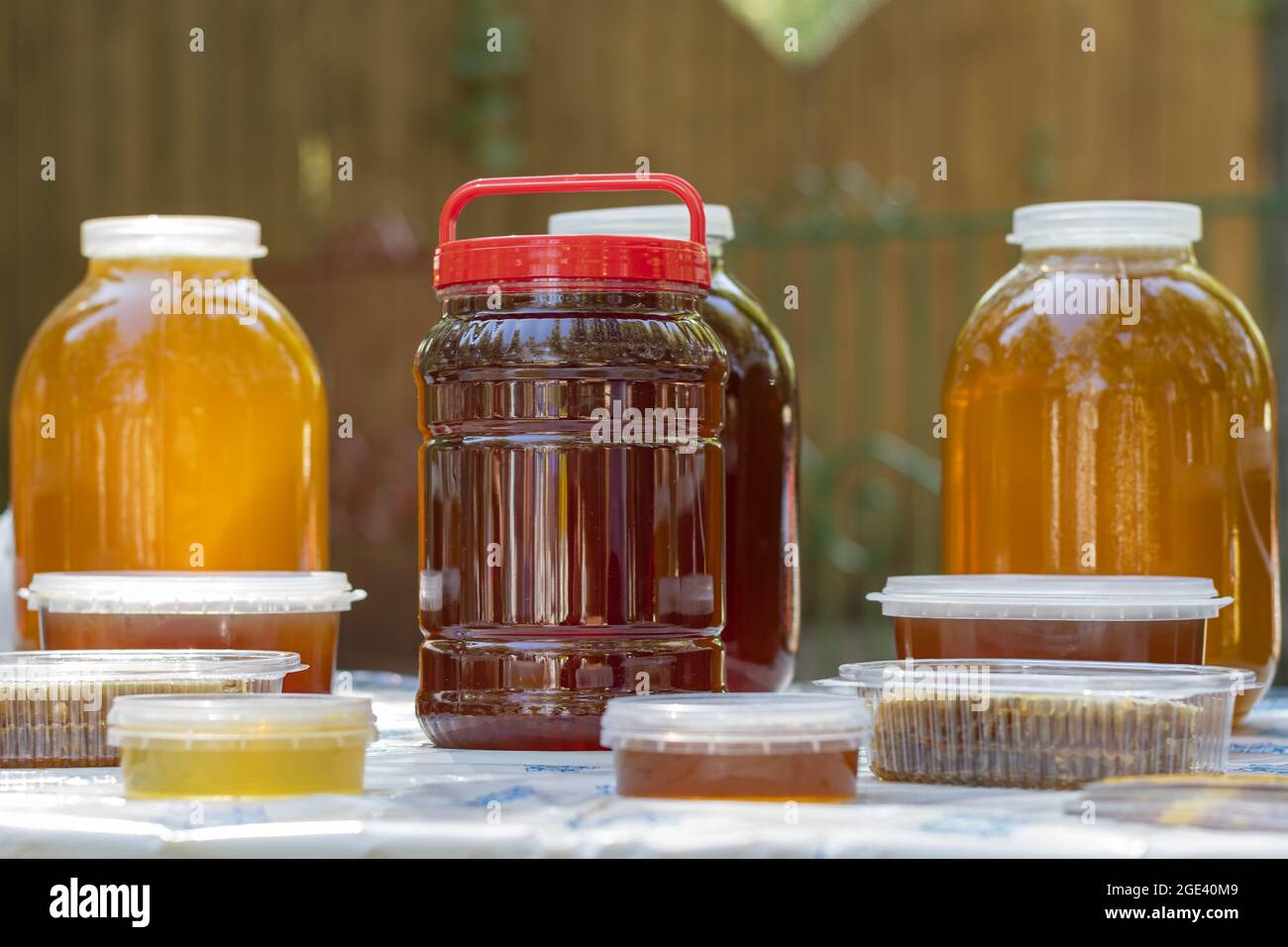 Bee honey is packaged in glass and plastic containers and is ready for ...