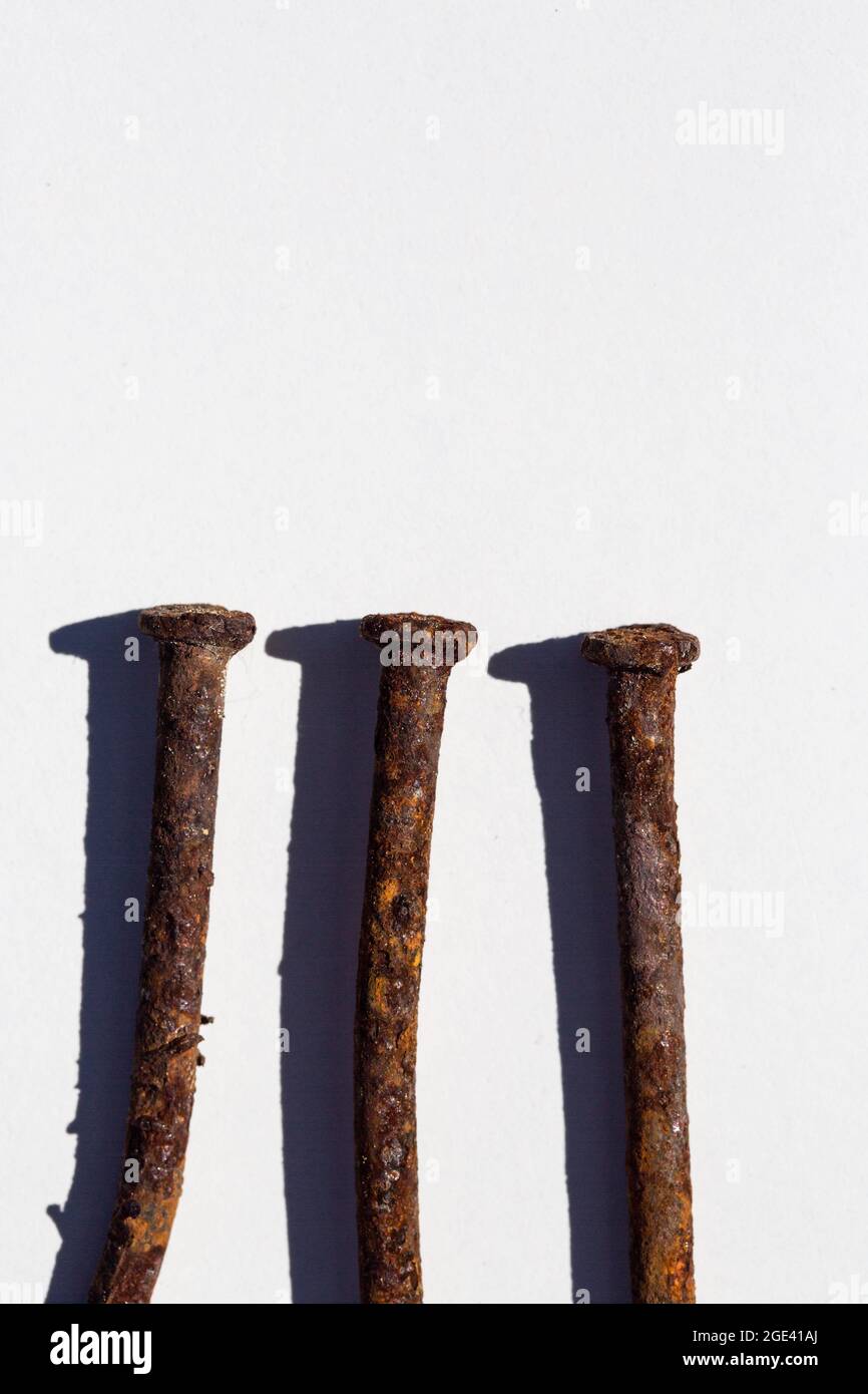 Three old rusty nails on white background Stock Photo - Alamy