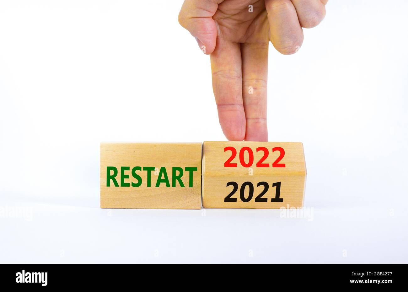 2022 restart new year symbol. Businessman turns a wooden cube and changes words 'Restart 2021 ...