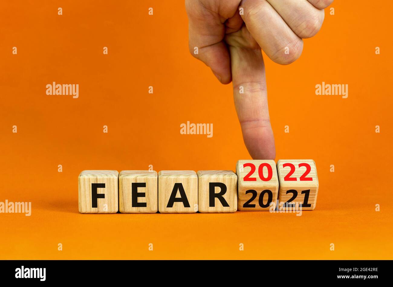 2022 fear new year symbol. Businessman turns a wooden cube and changes words 'Fear 2021' to ...