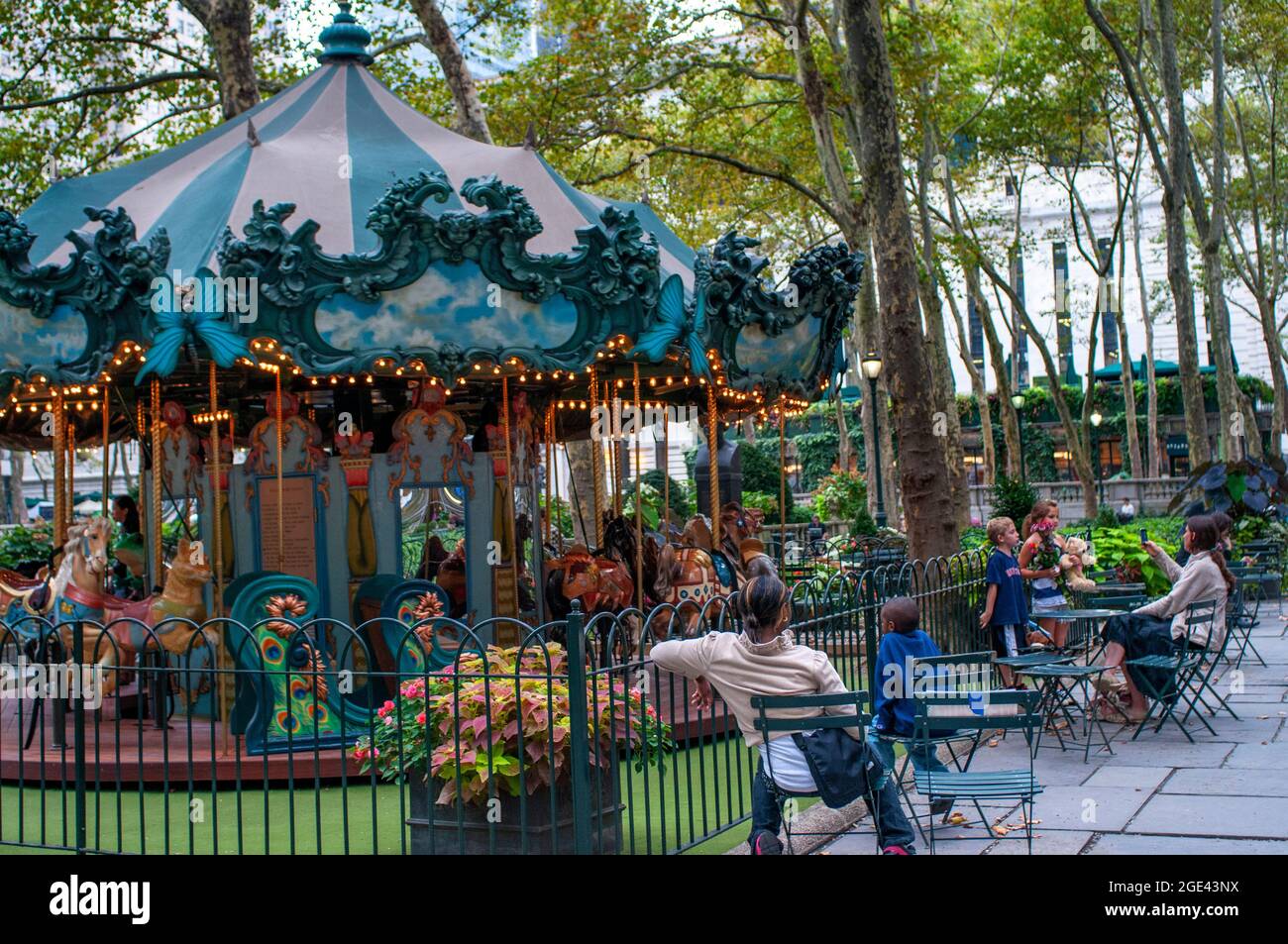 Children riding a carousel in the Winter Village at Bryant Park ...