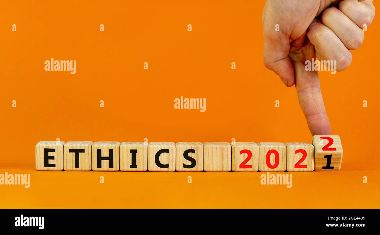 2022 ethics and new year symbol. Businessman turns wooden cubes and ...